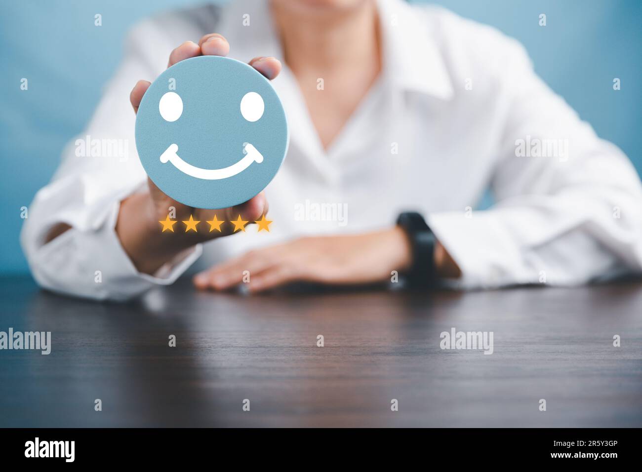 Woman hand holding happy face smile face icon on round blue object ...