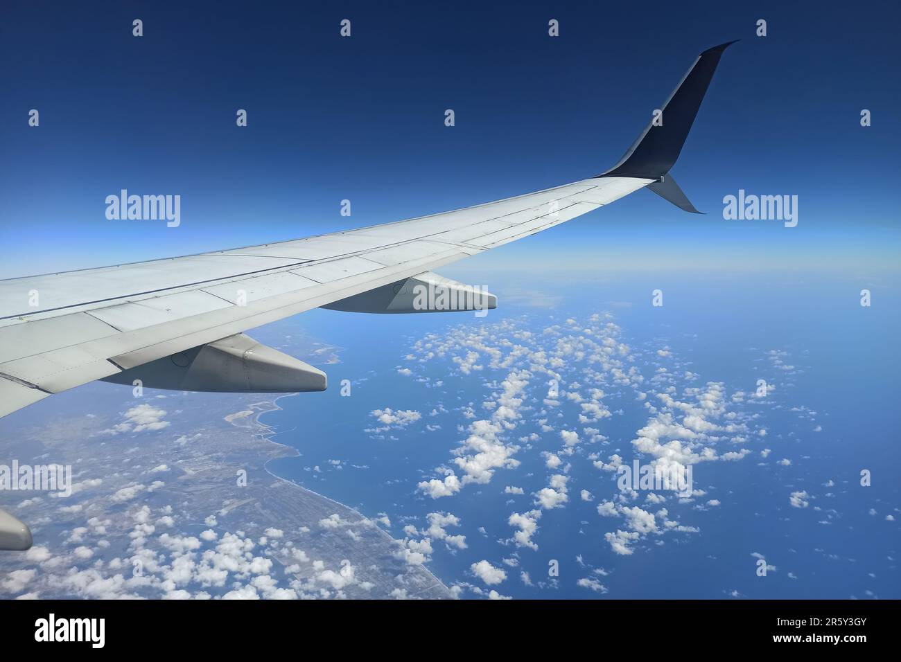 View through airplane window of commercial jet plane wing flying high ...