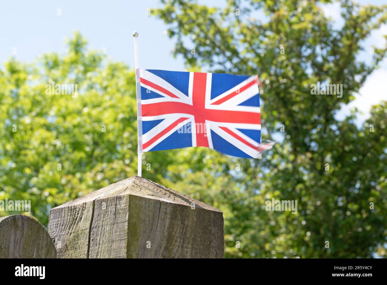 Union Jack flag on old fence post and trees in background Stock Photo ...
