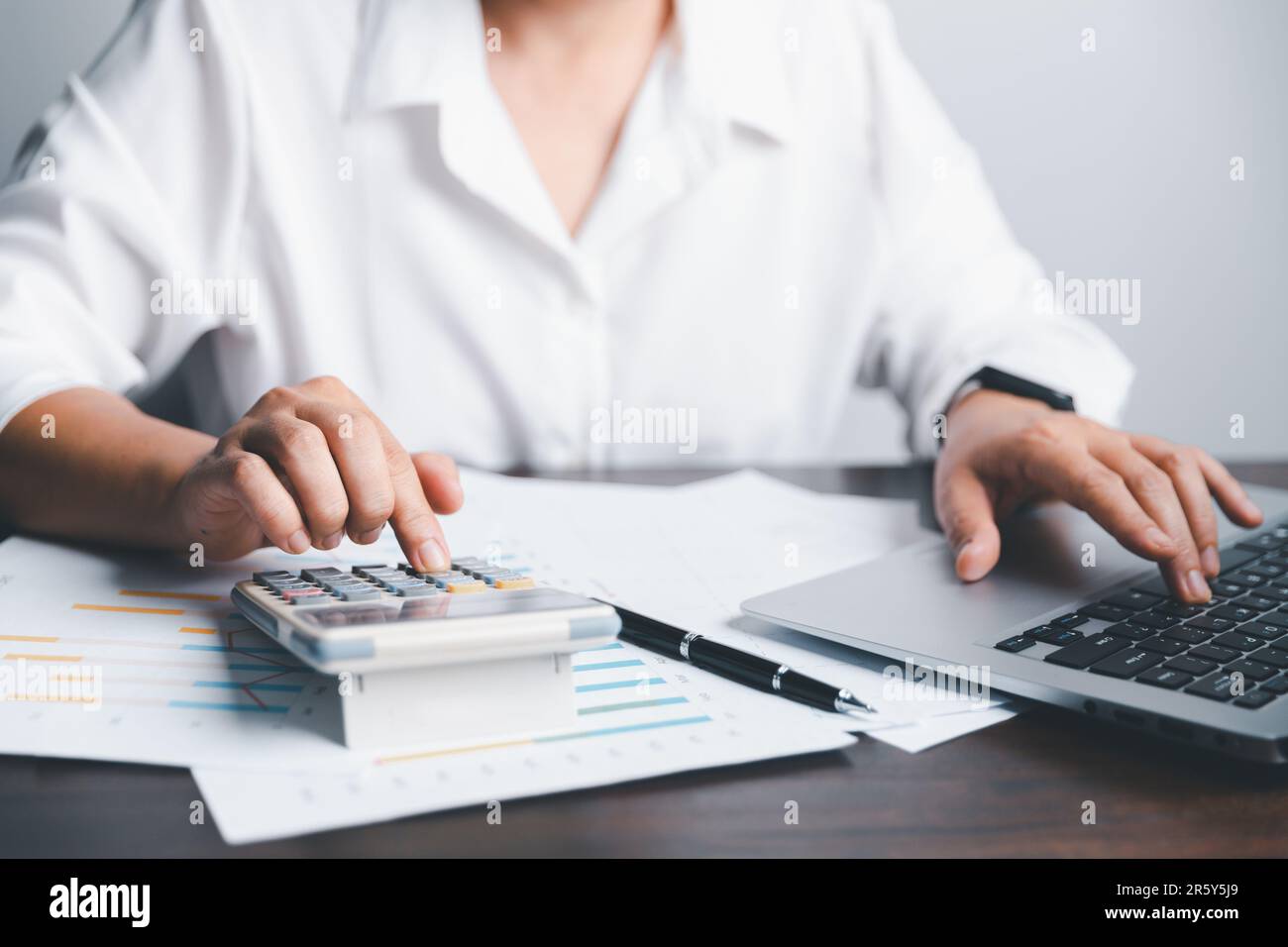 Close up woman with calculator counting making notes at home, hand is ...