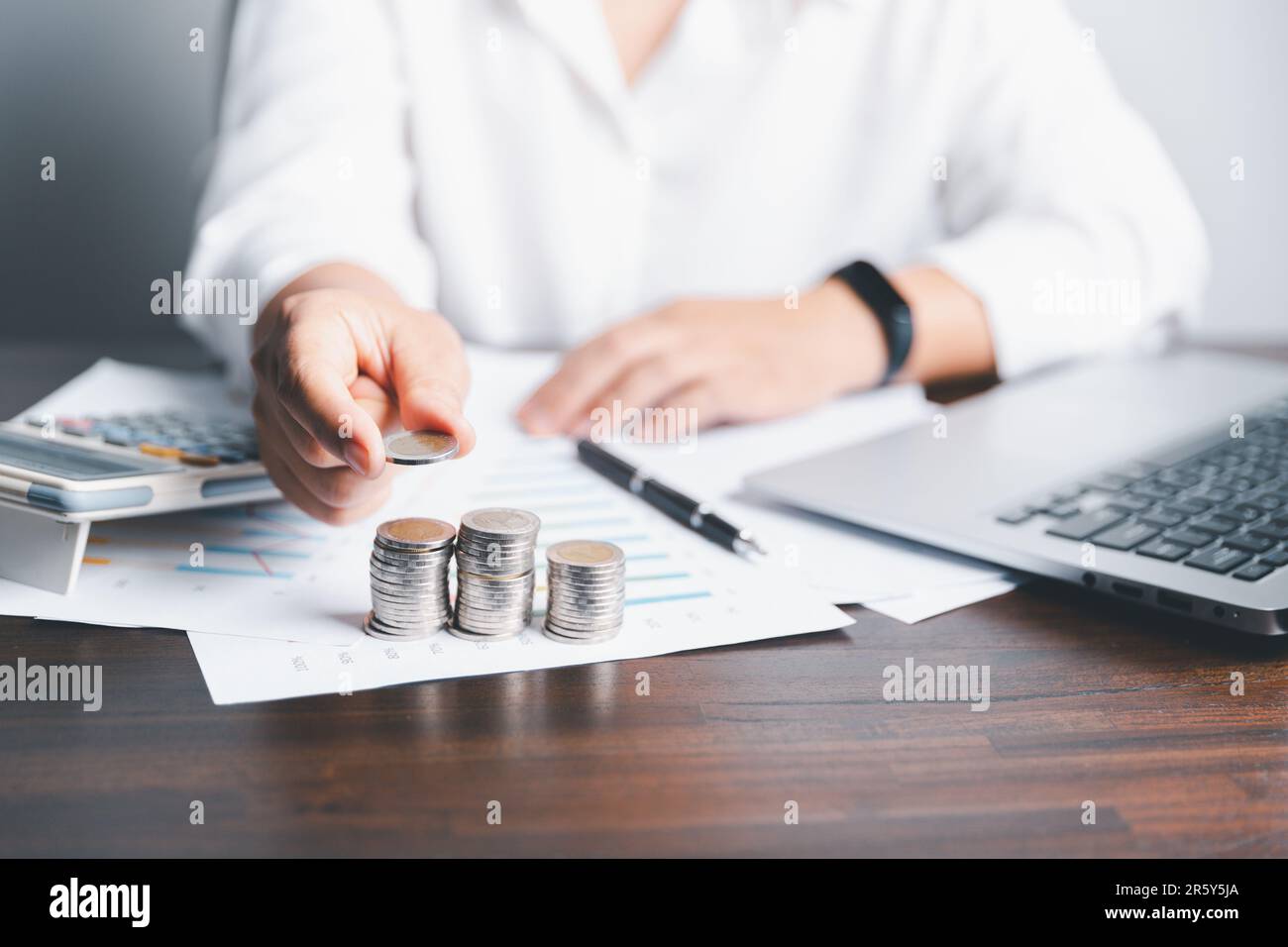 Saving money concept preset by female hand putting money coin stack ...