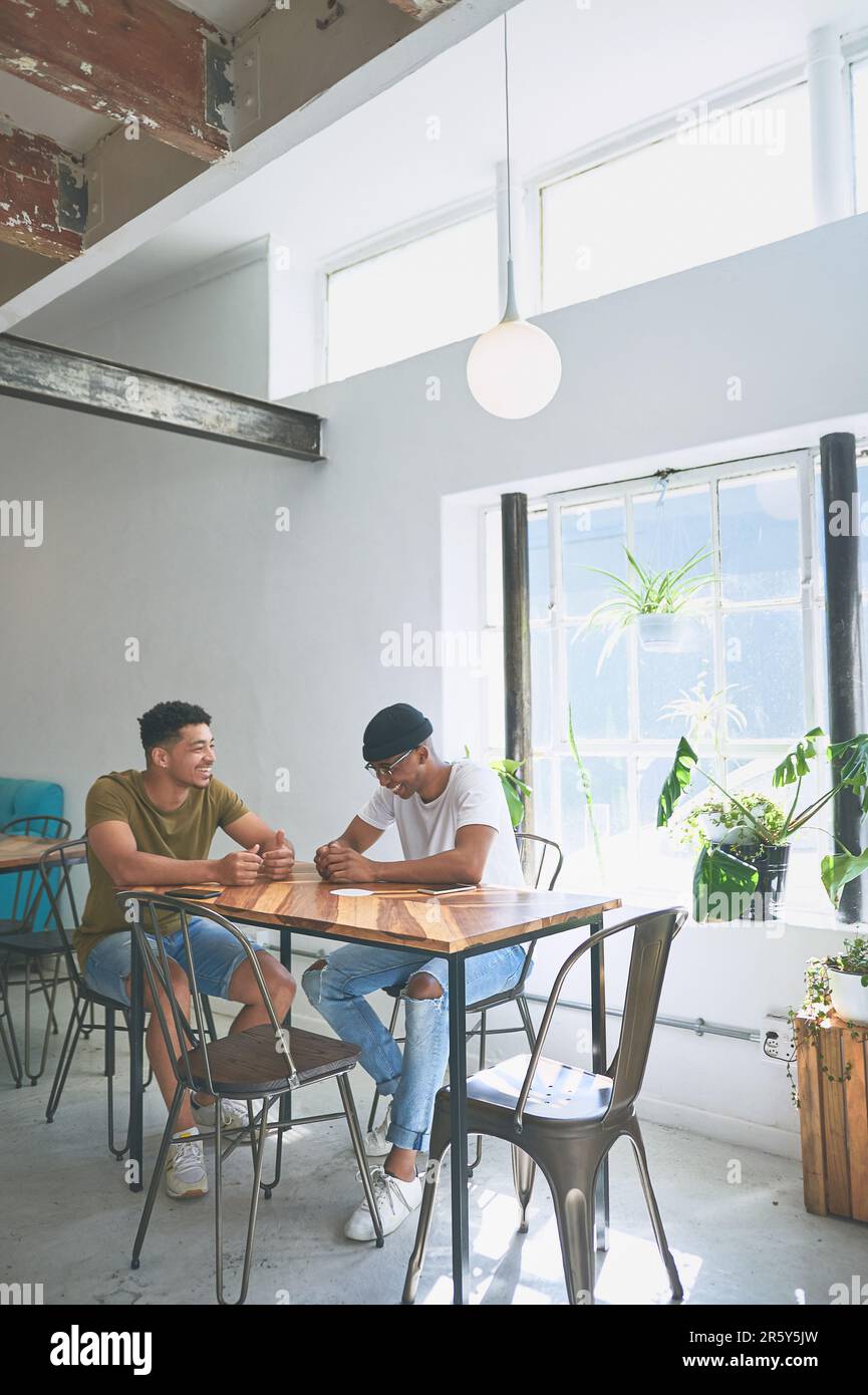 Two brothers talking together sitting hi-res stock photography and ...