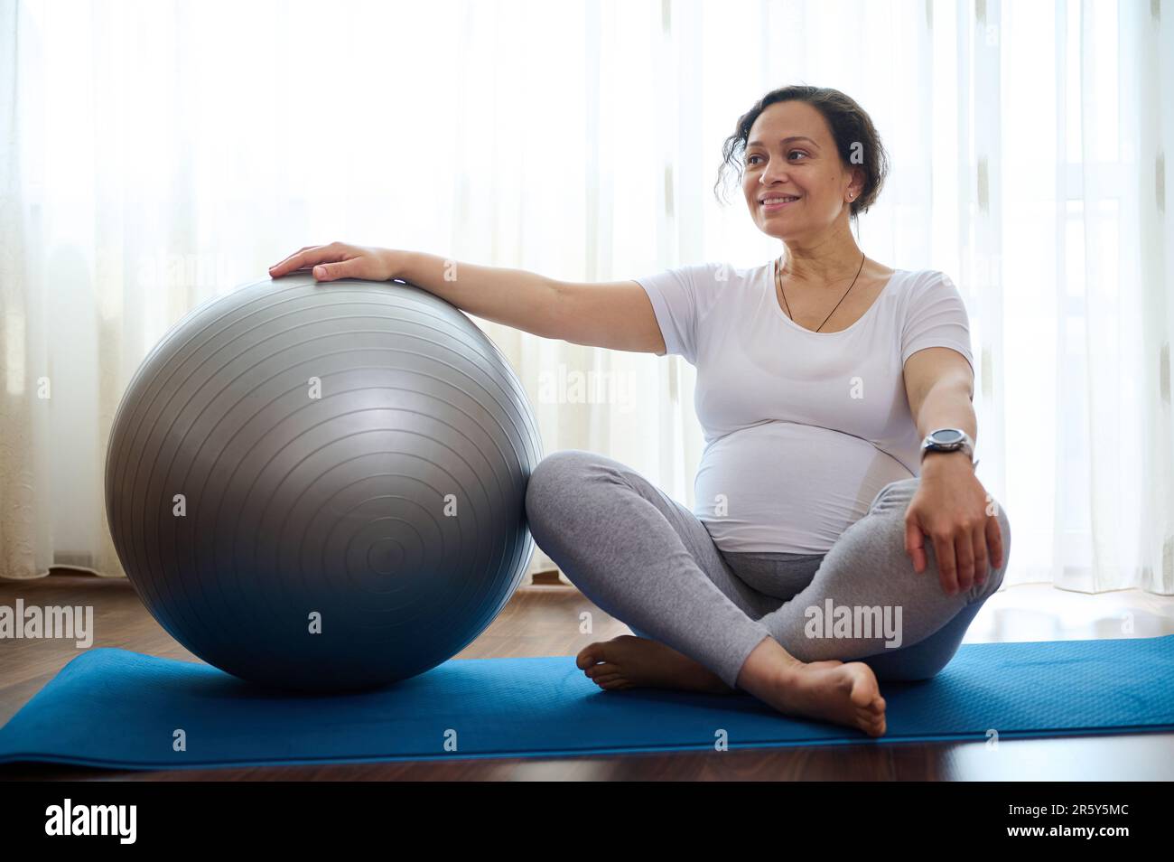 Happy pregnant expectant mother smiles looking aside, enjoying active ...