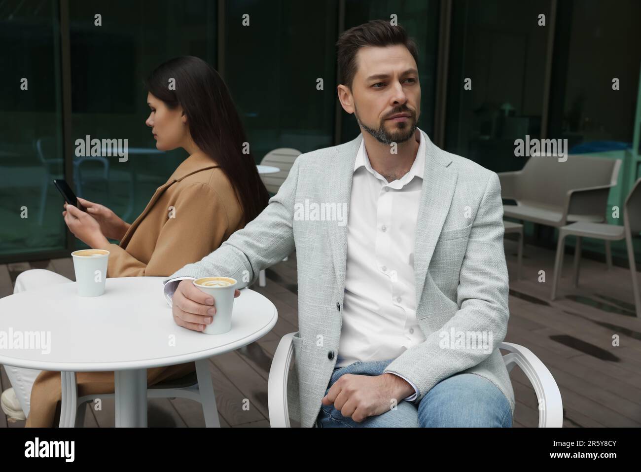 Upset arguing couple in outdoor cafe. Relationship problems Stock Photo ...