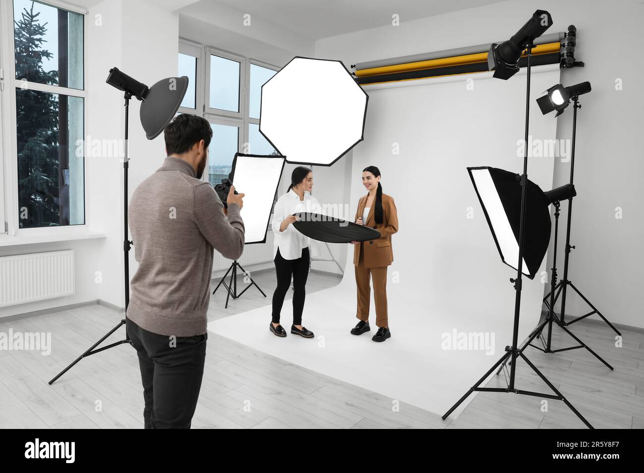 Professional photographer and assistant working with beautiful model in ...
