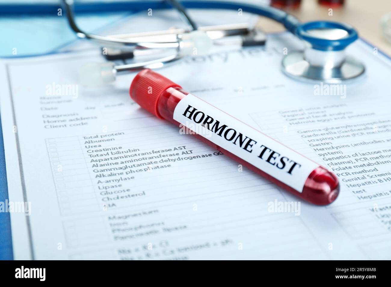 Hormone test. Sample tube with blood and stethoscope on laboratory ...