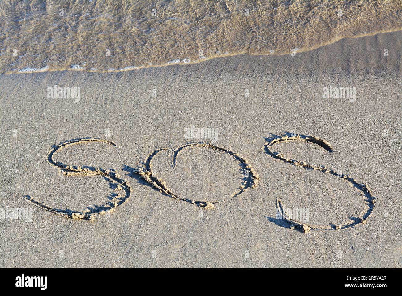 Sos message written on sand hi-res stock photography and images - Alamy