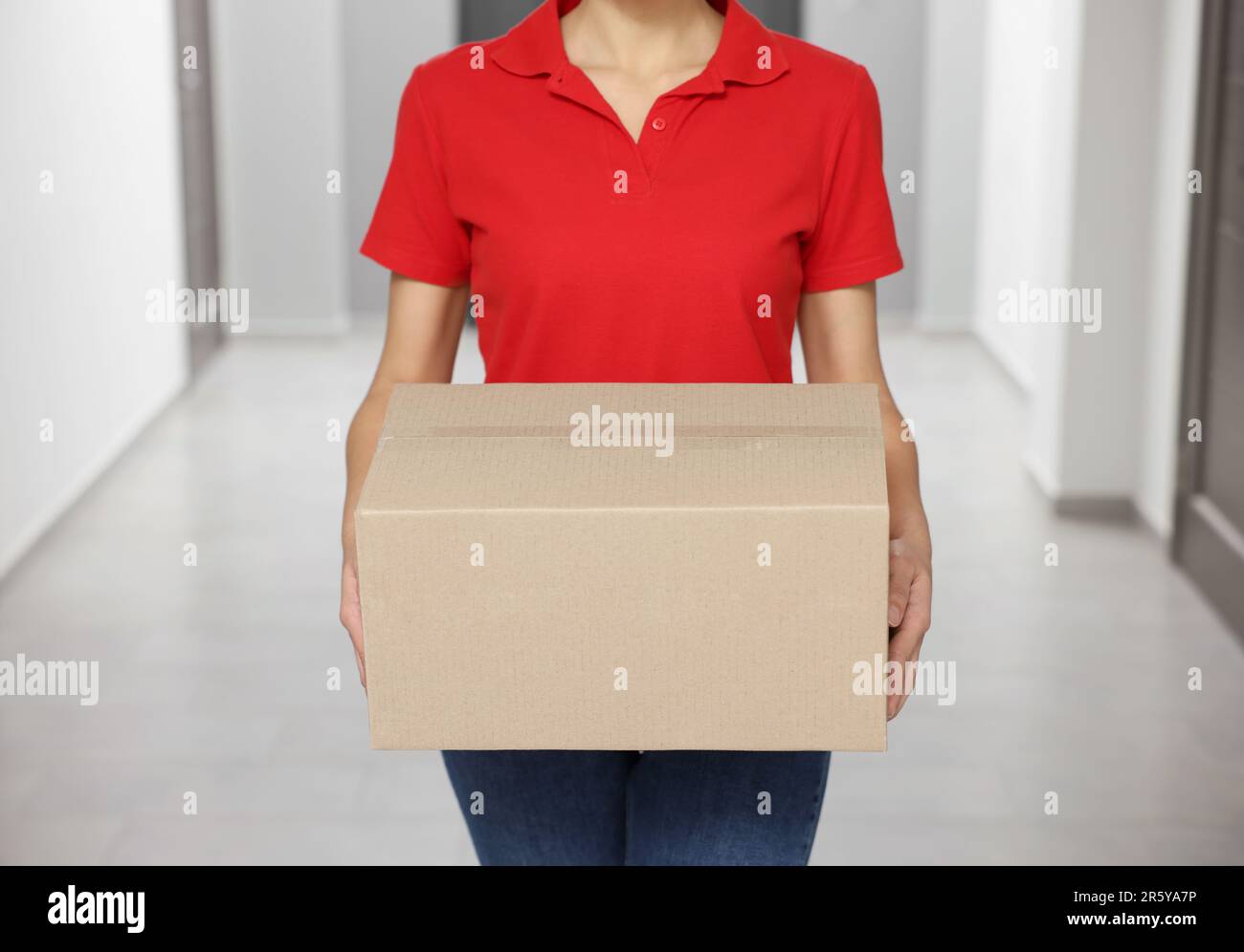 Courier with cardboard boxes in hallway, closeup Stock Photo - Alamy