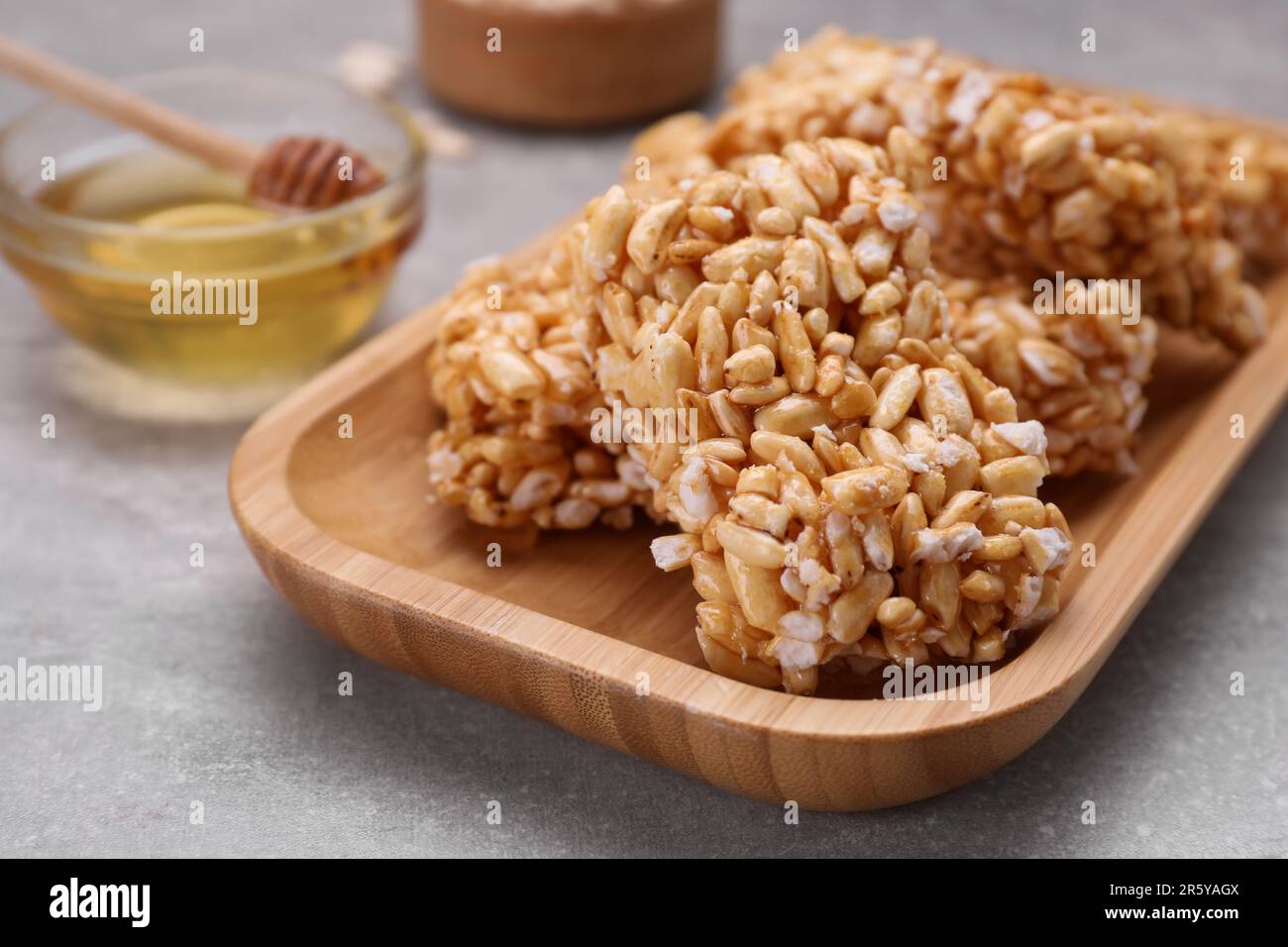 Plate with puffed rice pieces (kozinaki) on grey table, closeup Stock ...