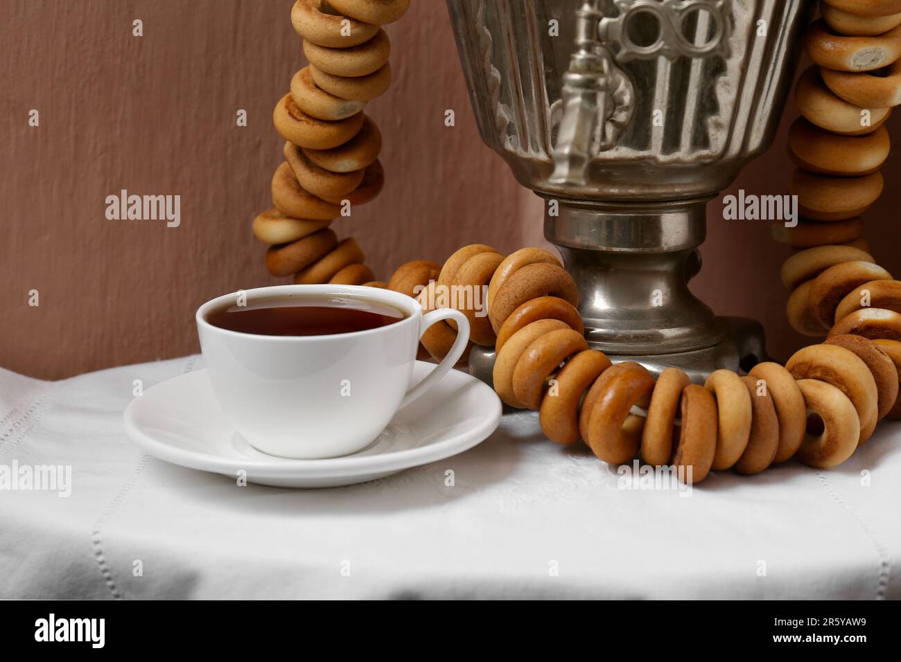 Vintage samovar, cup of hot drink and dry bagels served on table ...