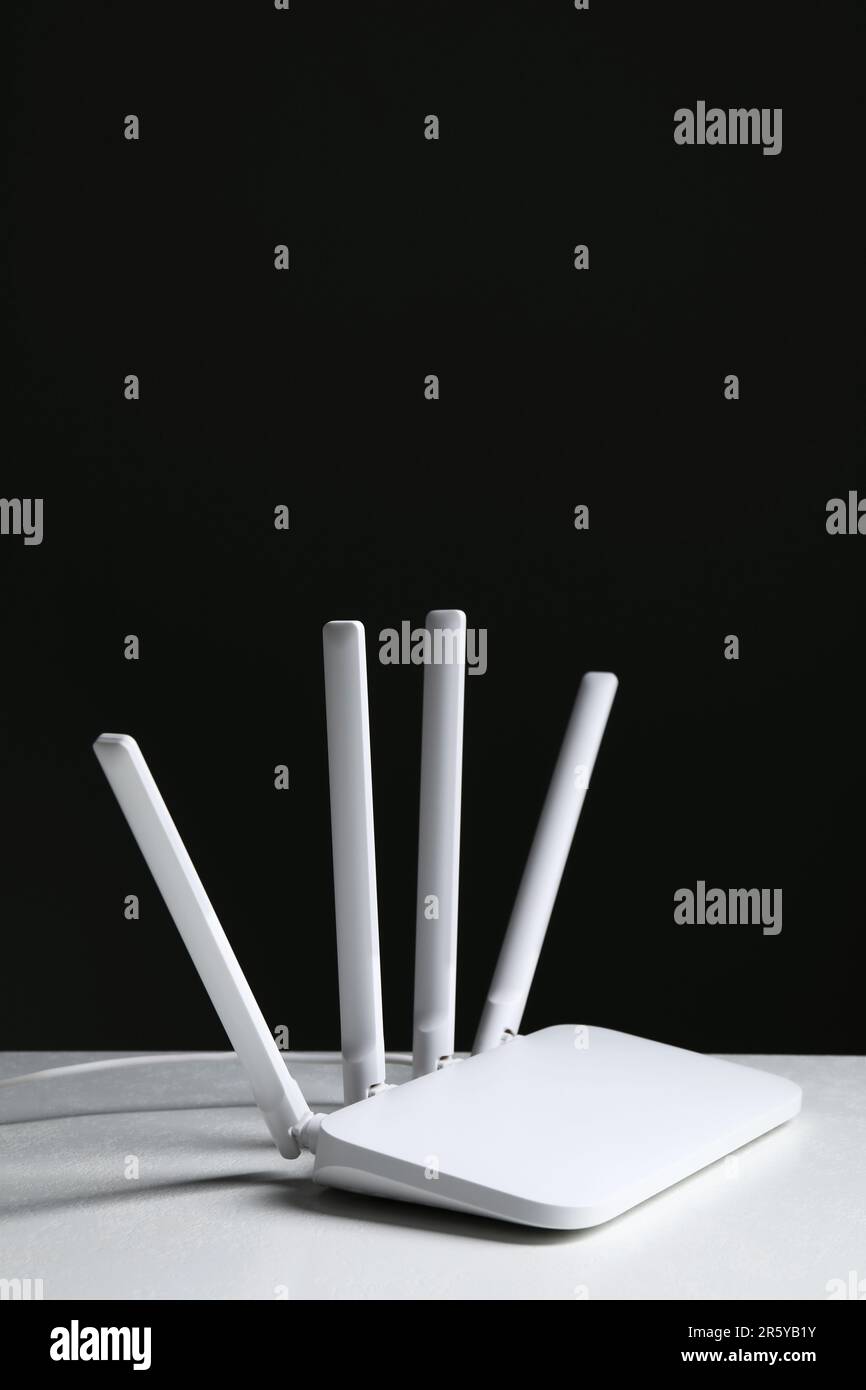 New modern Wi-Fi router on white table against black background Stock ...