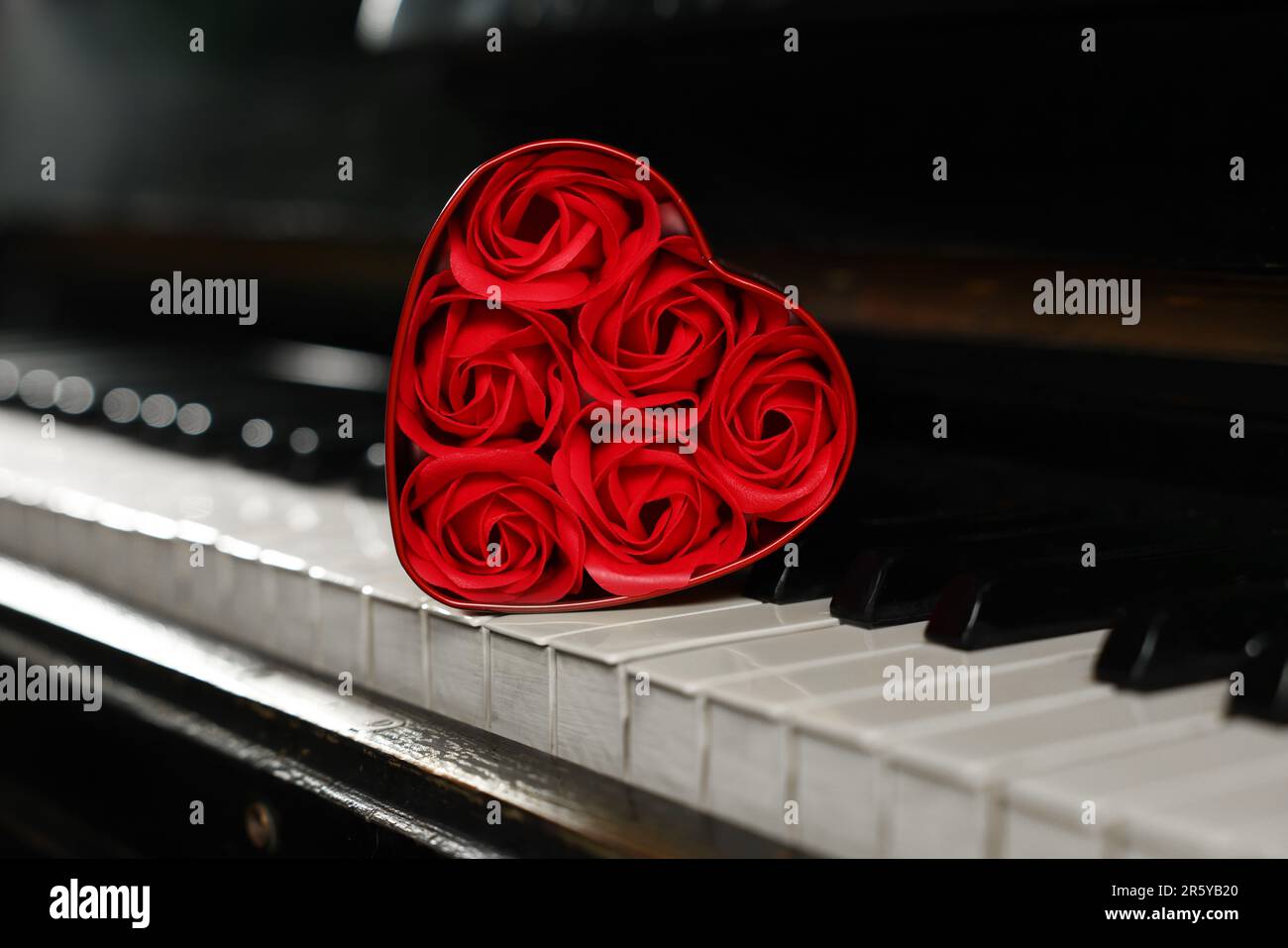 Beautiful red roses in heart shaped box on piano keys, closeup Stock ...