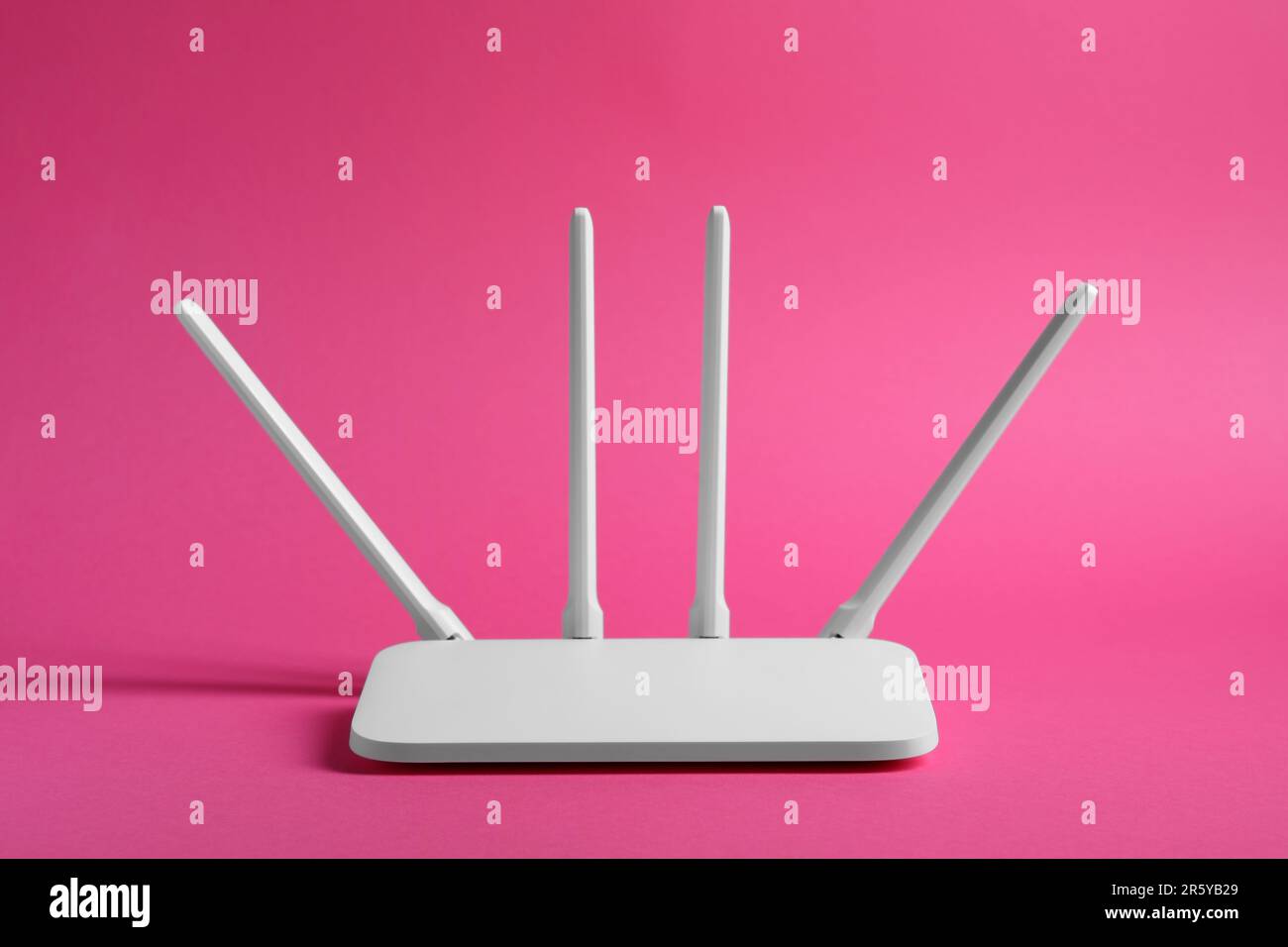 New white Wi-Fi router on pink background Stock Photo - Alamy