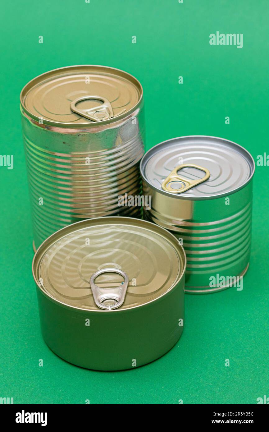 A Group of Stacked Tin Cans with Blank Edges on Green Background ...