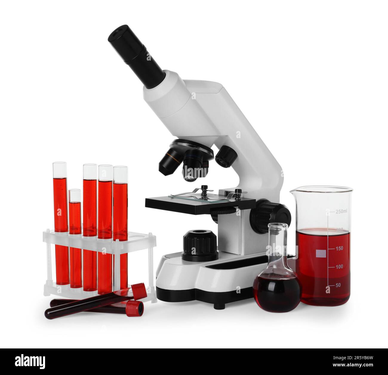 Laboratory glassware with red liquid and microscope isolated on white ...