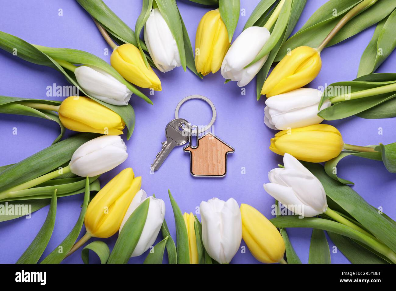 Beautiful spring flowers and key with trinket in shape of house on ...