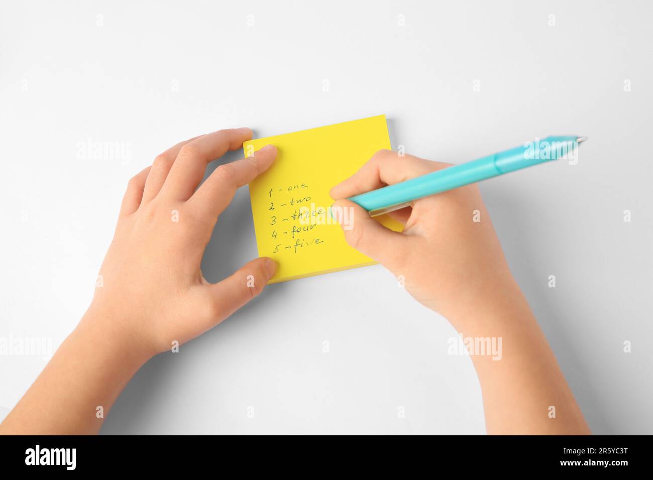 Child erasing words and numbers written with erasable pen on white ...