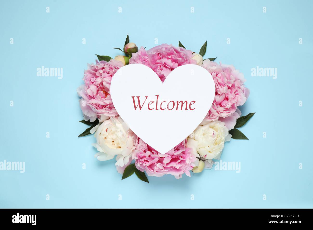 Welcome card in shape of heart and beautiful peonies on light blue ...