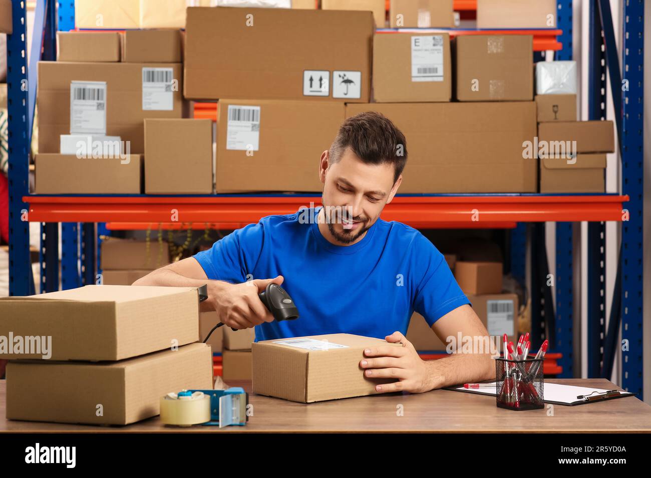 Post office worker with scanner reading parcel barcode at counter ...