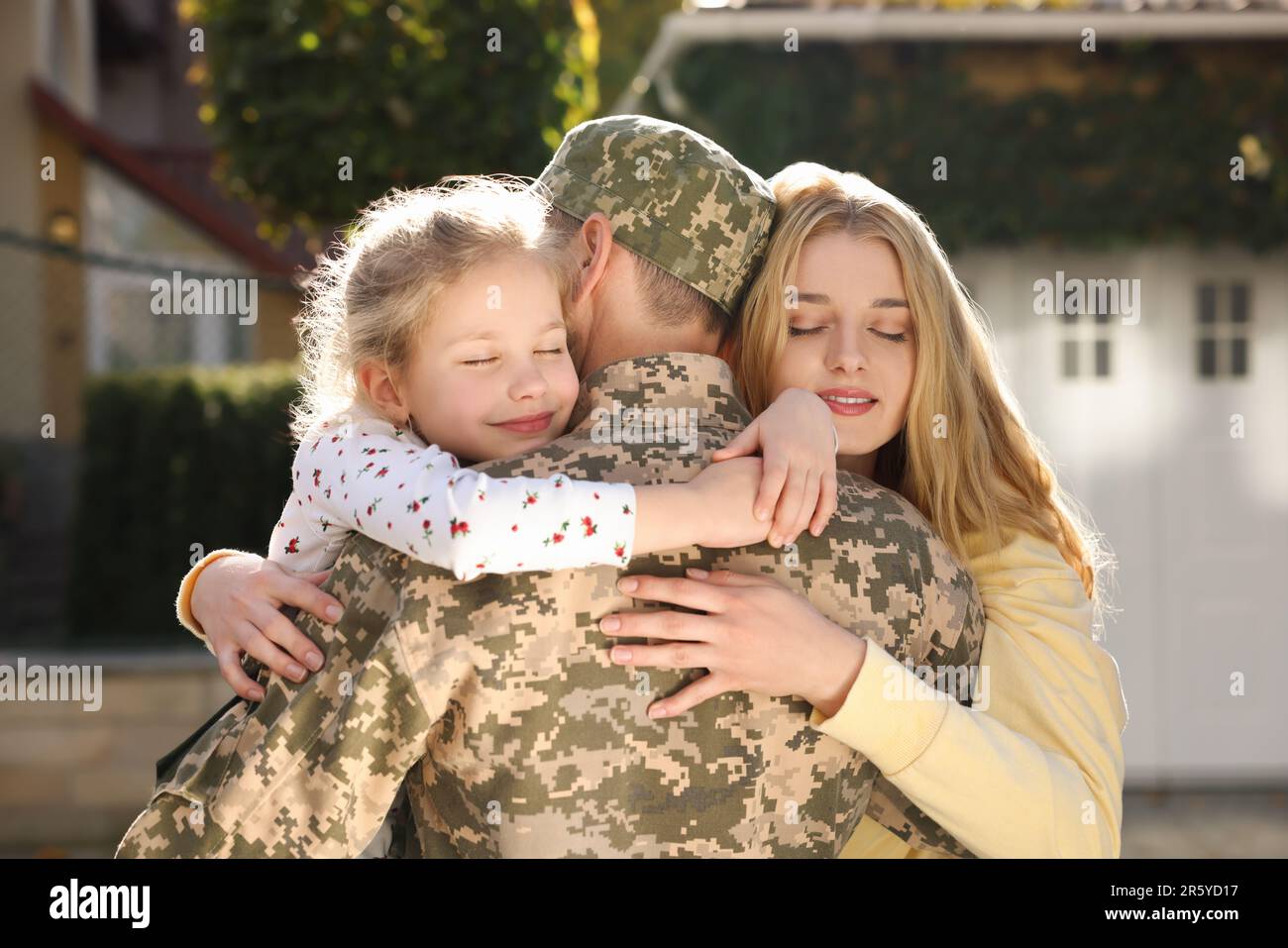 Daughter and wife hugging soldier in Ukrainian military uniform ...