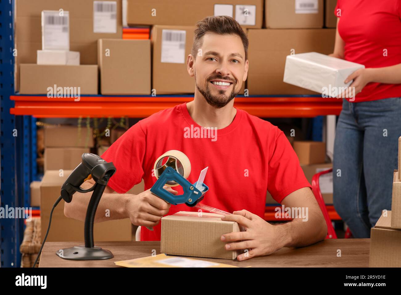 Post office worker packing parcel at counter indoors Stock Photo - Alamy