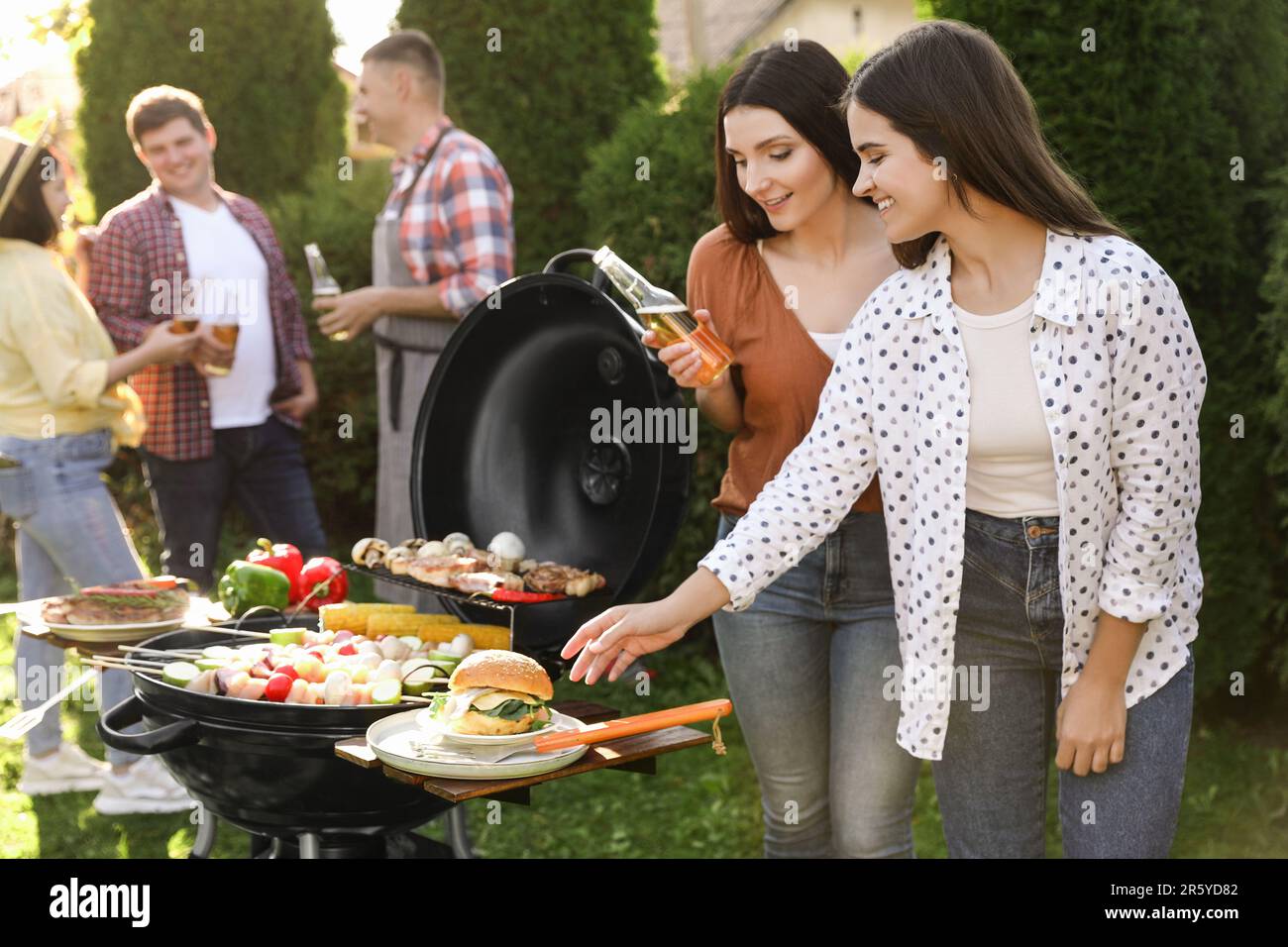 Group of friends having barbecue party outdoors Stock Photo - Alamy