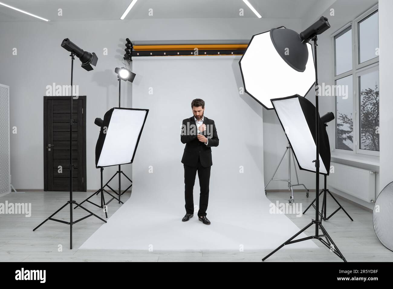 Handsome model posing in modern studio. Professional photo session ...