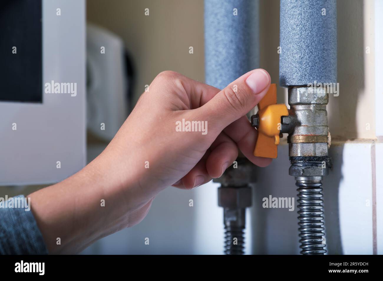 Woman turning on valve hi-res stock photography and images - Alamy