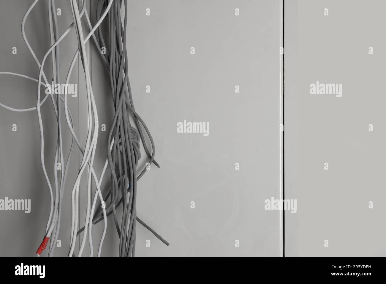 Different cables on white wall indoors. Installation of electrical ...