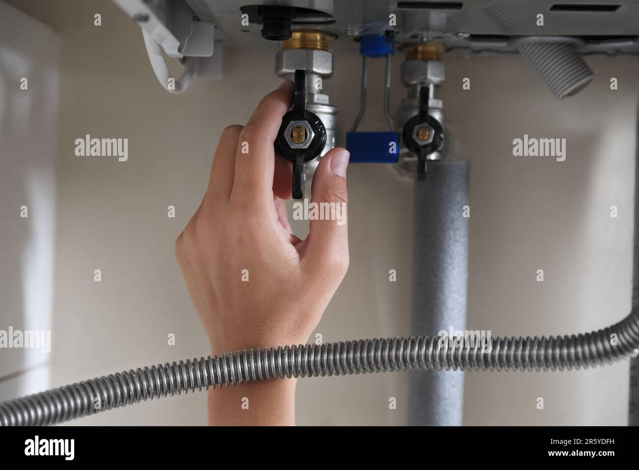 Woman turning on valve hi-res stock photography and images - Alamy