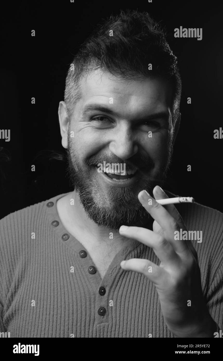 Smiling man smoking cigarette. Smoke on black Stock Photo - Alamy
