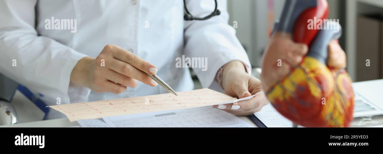 Cardiologist doctor holding and reading an ecg paper report of patient ...
