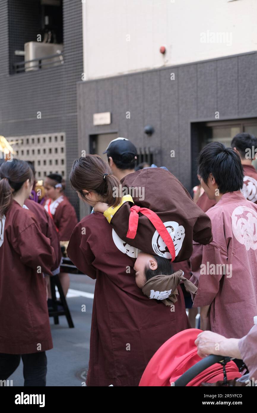 kid carried by her mother during kanda festifal Stock Photo - Alamy