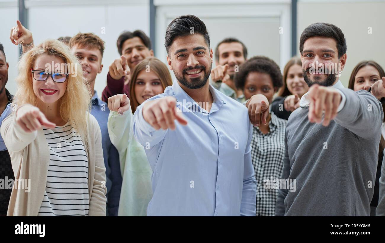 Join a successful team. Young people point to you Stock Photo - Alamy