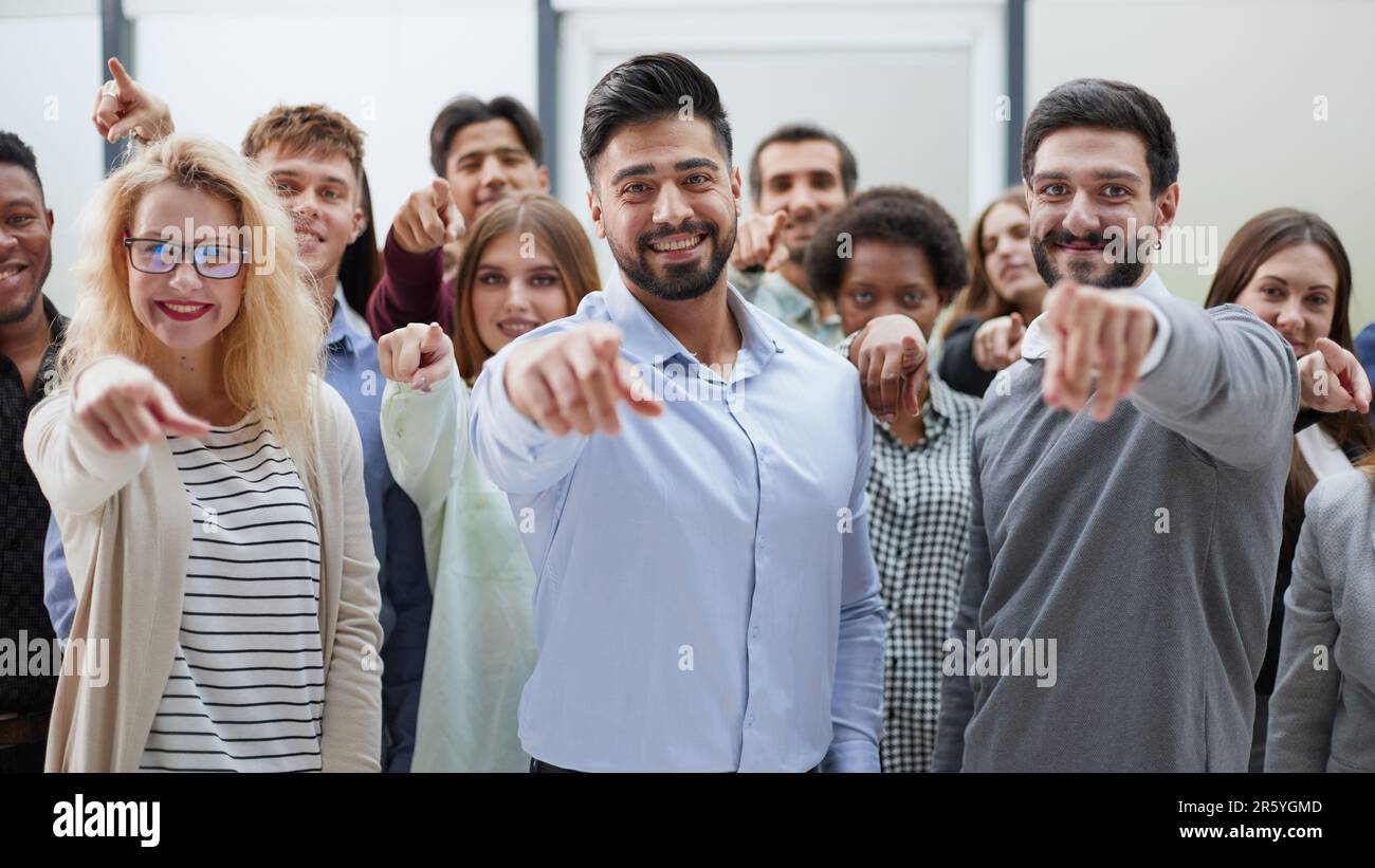 Join a successful team. Young people point to you Stock Photo - Alamy
