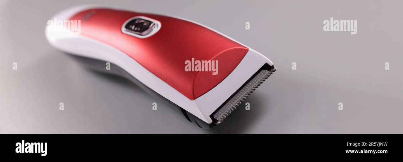 Red hair clipper on a gray background Stock Photo - Alamy