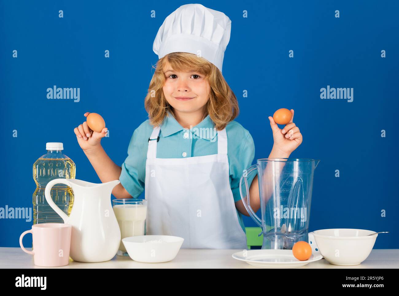 Child hold eggs wearing cooker uniform and chef hat preparing ...