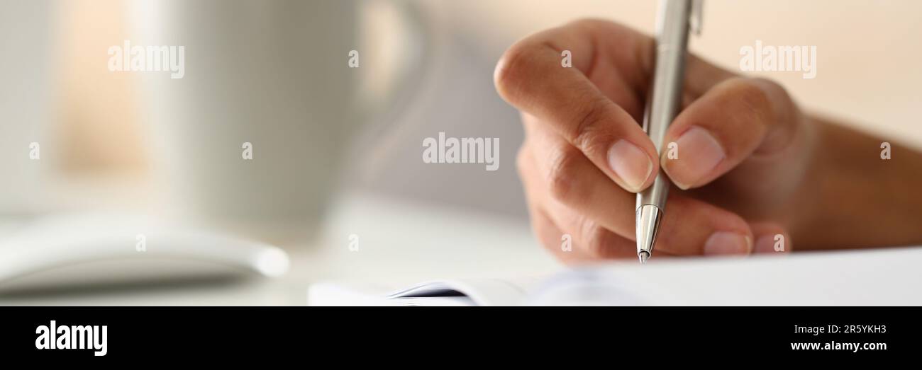 Closeup cropped hands of young woman writing day plan in notebook at ...