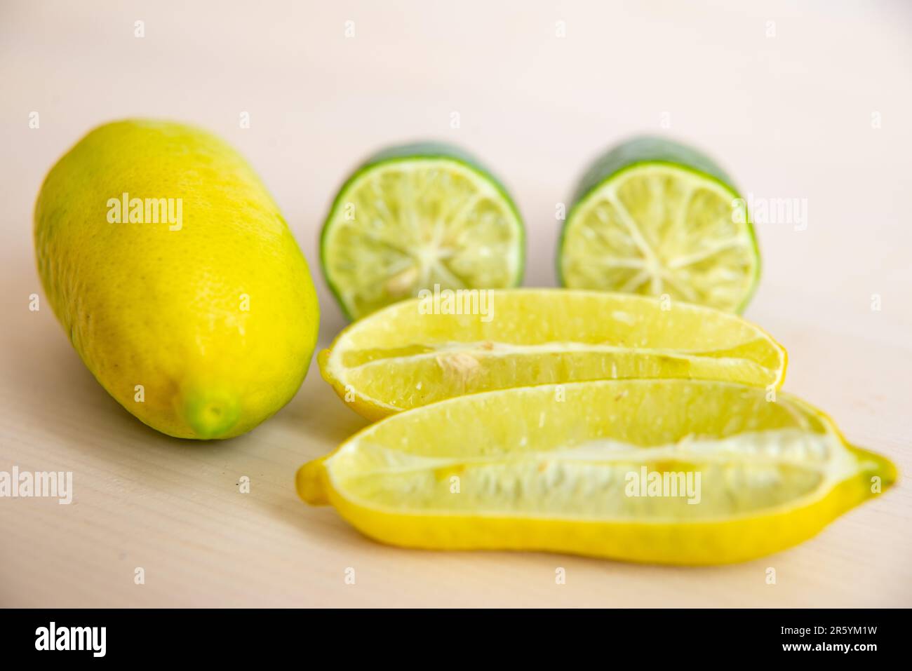 Finger lime, cut in half, on a white surface Stock Photo - Alamy