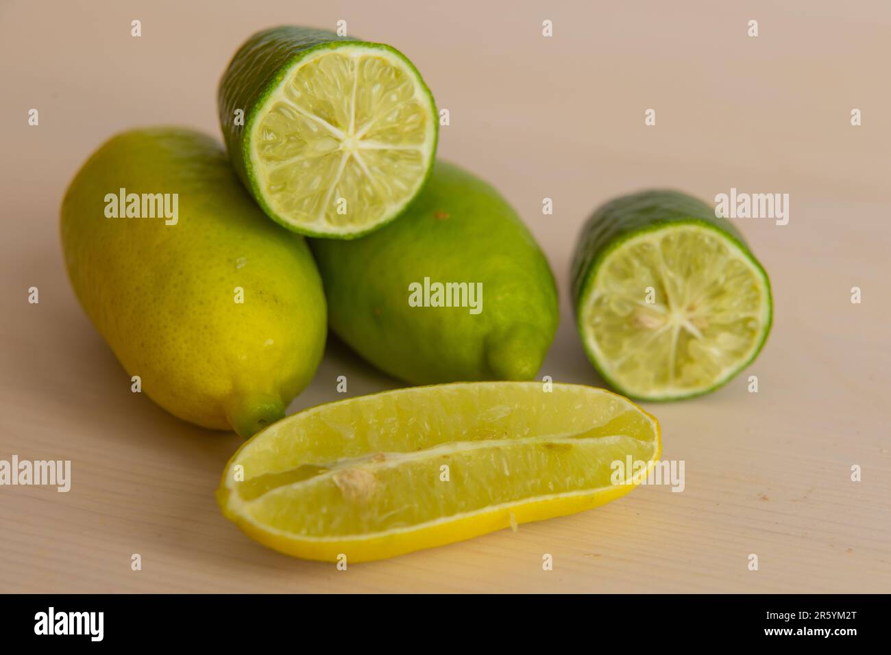Finger lime, cut in half, on a white surface Stock Photo - Alamy