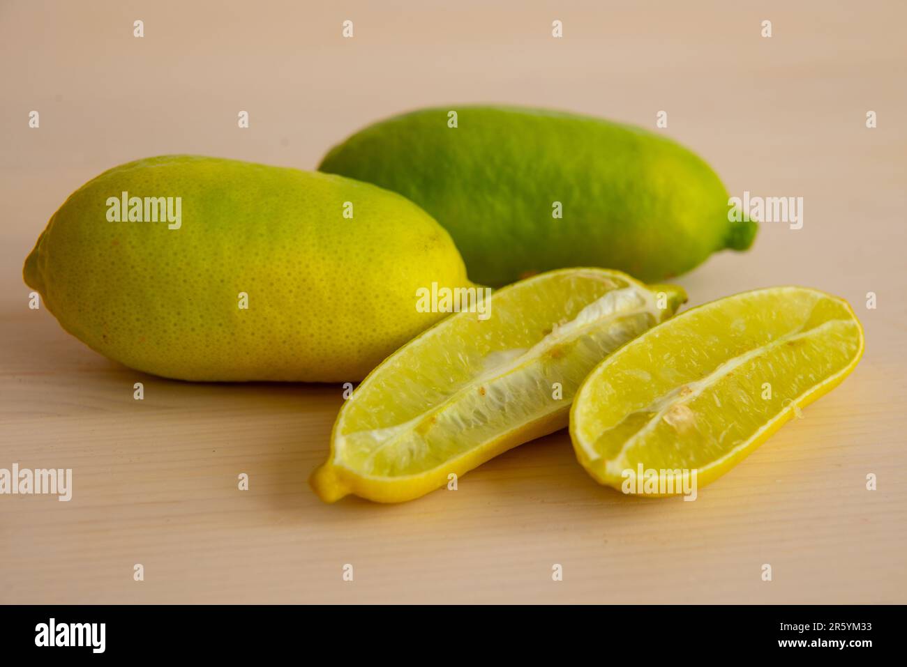 Finger lime, cut in half, on a white surface Stock Photo - Alamy