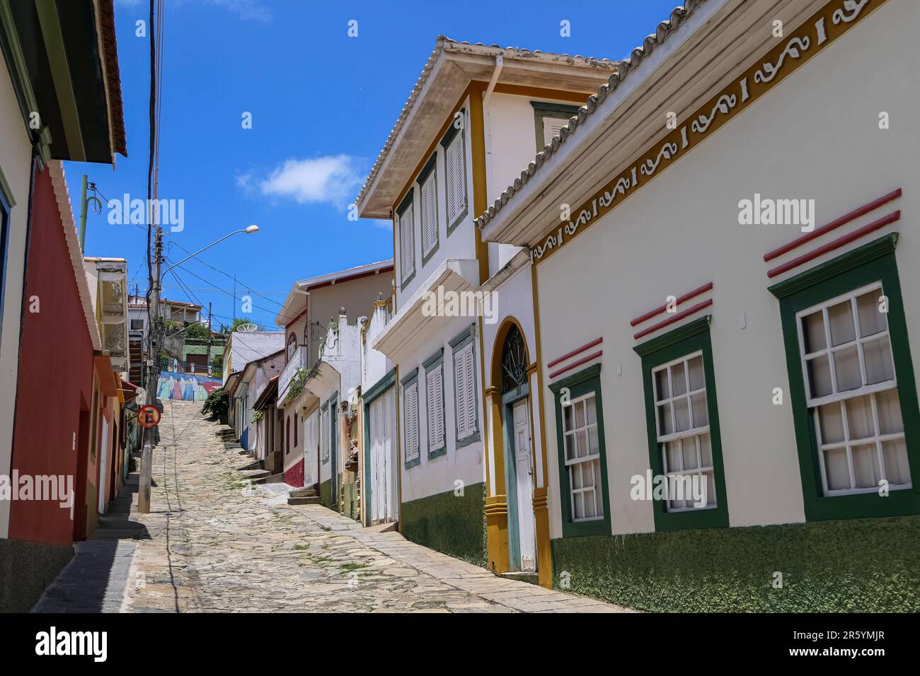 Steep cobblestone street with traditional houses in historical town São ...
