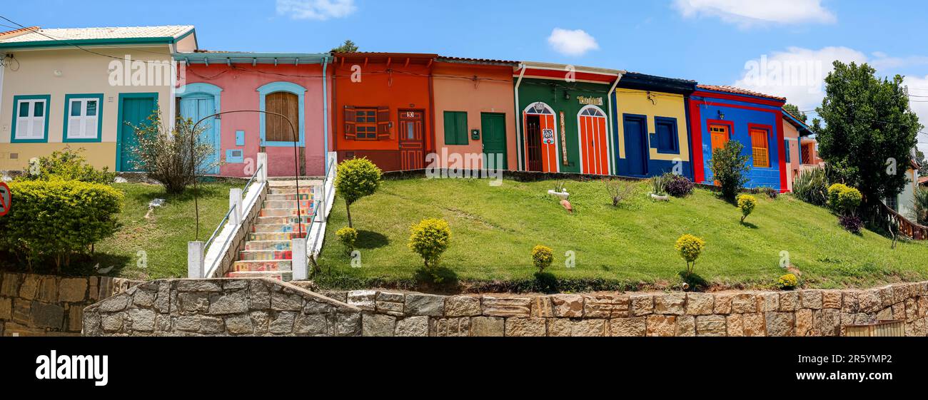 Panorama of row of colorful house facades and green space with blue sky ...