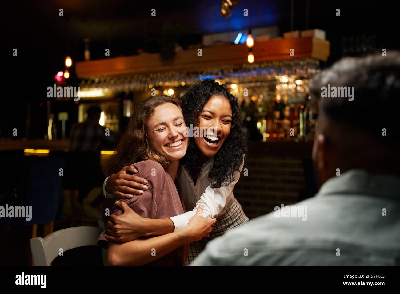 Women friends embracing restaurant hi-res stock photography and images ...