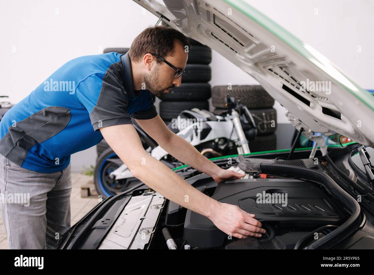 Male mechanic examining and maintenance to customer the engine. Open ...
