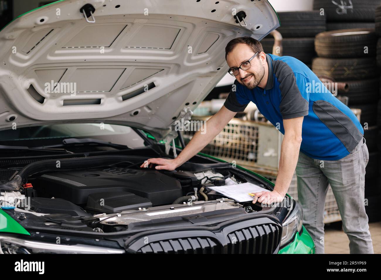 Male mechanic examining and maintenance to customer the engine. Open ...