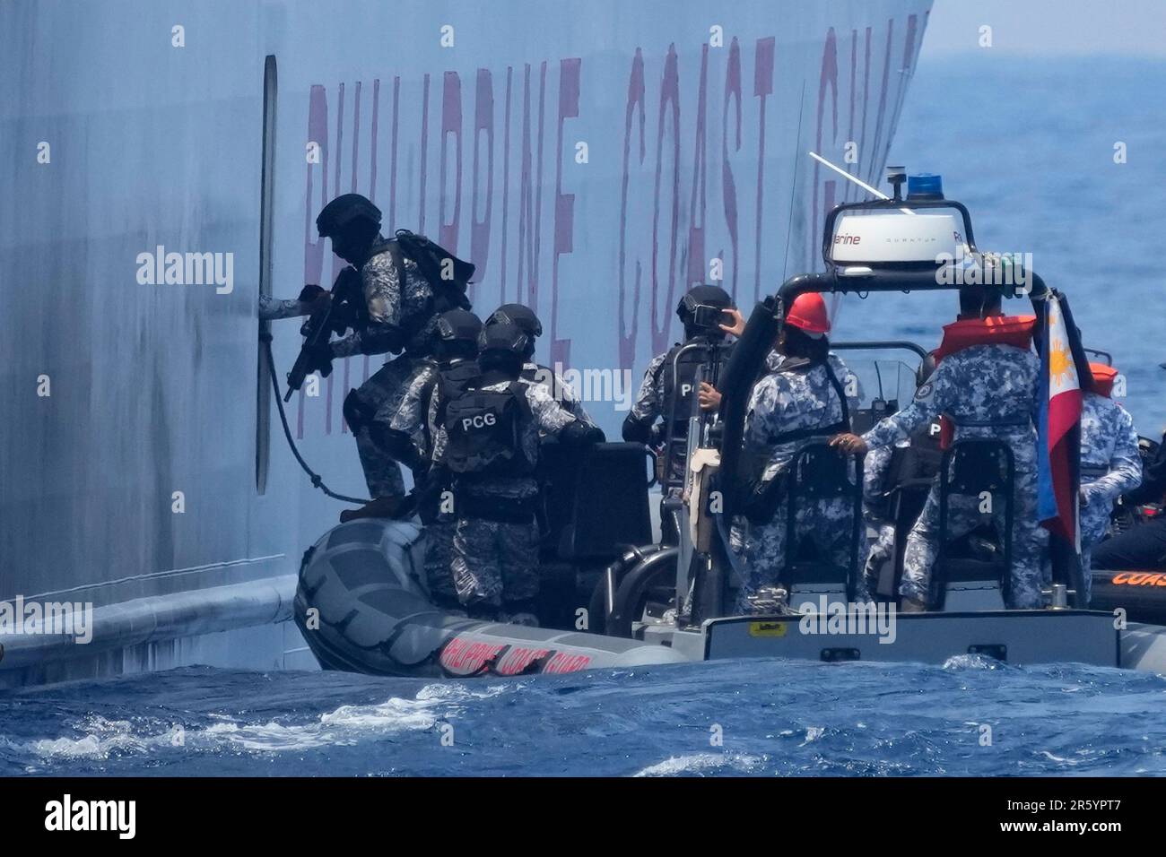 Armed Philippine Coast Guard personnel board the PCG Melchora Aquino ...