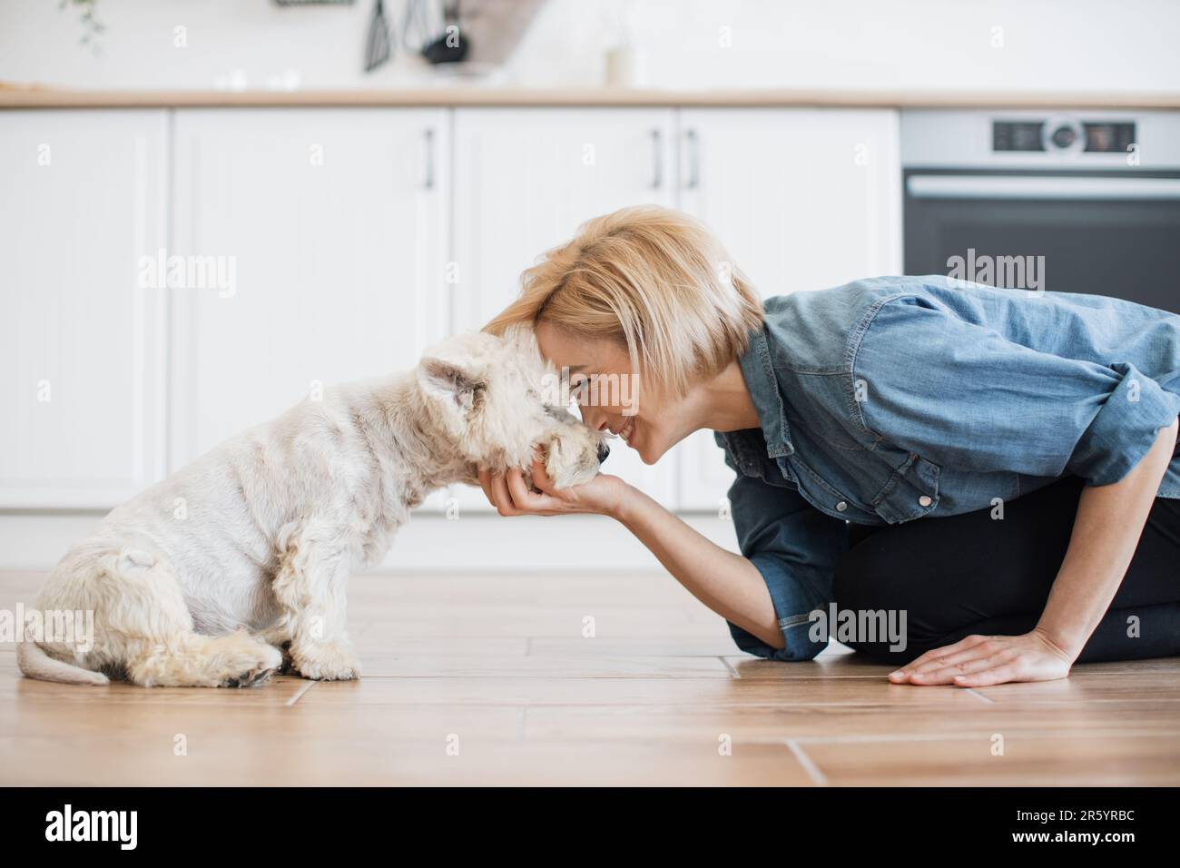 Cheerful caucasian woman leaning forward with her legs underneath body ...