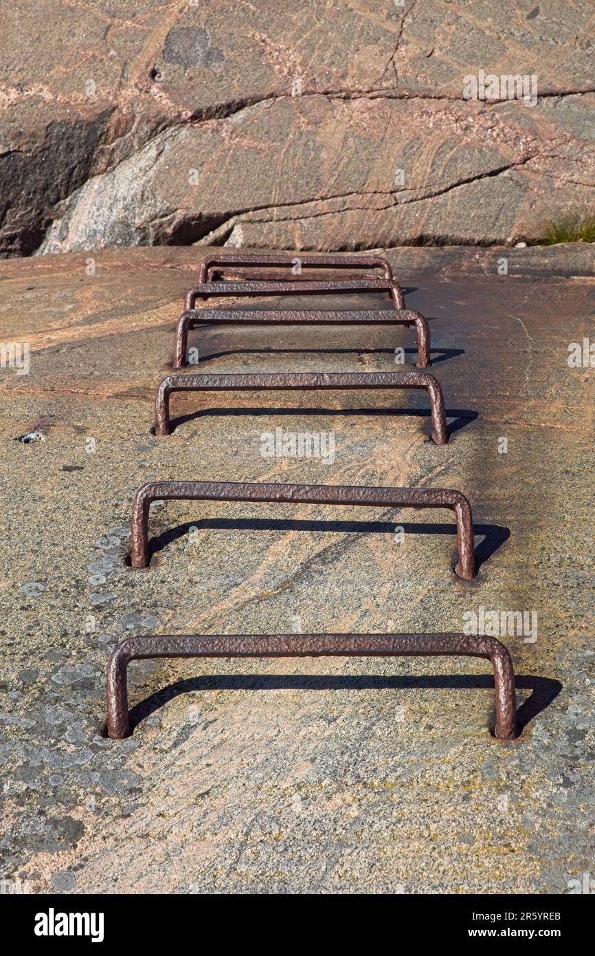 Metal rungs on rock wall to climb up Stock Photo - Alamy