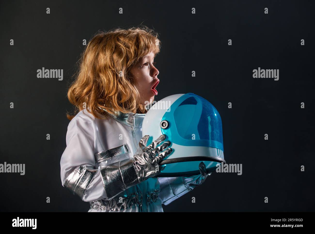 Cute little excited boy spaceman child in space suit holding helmet on ...